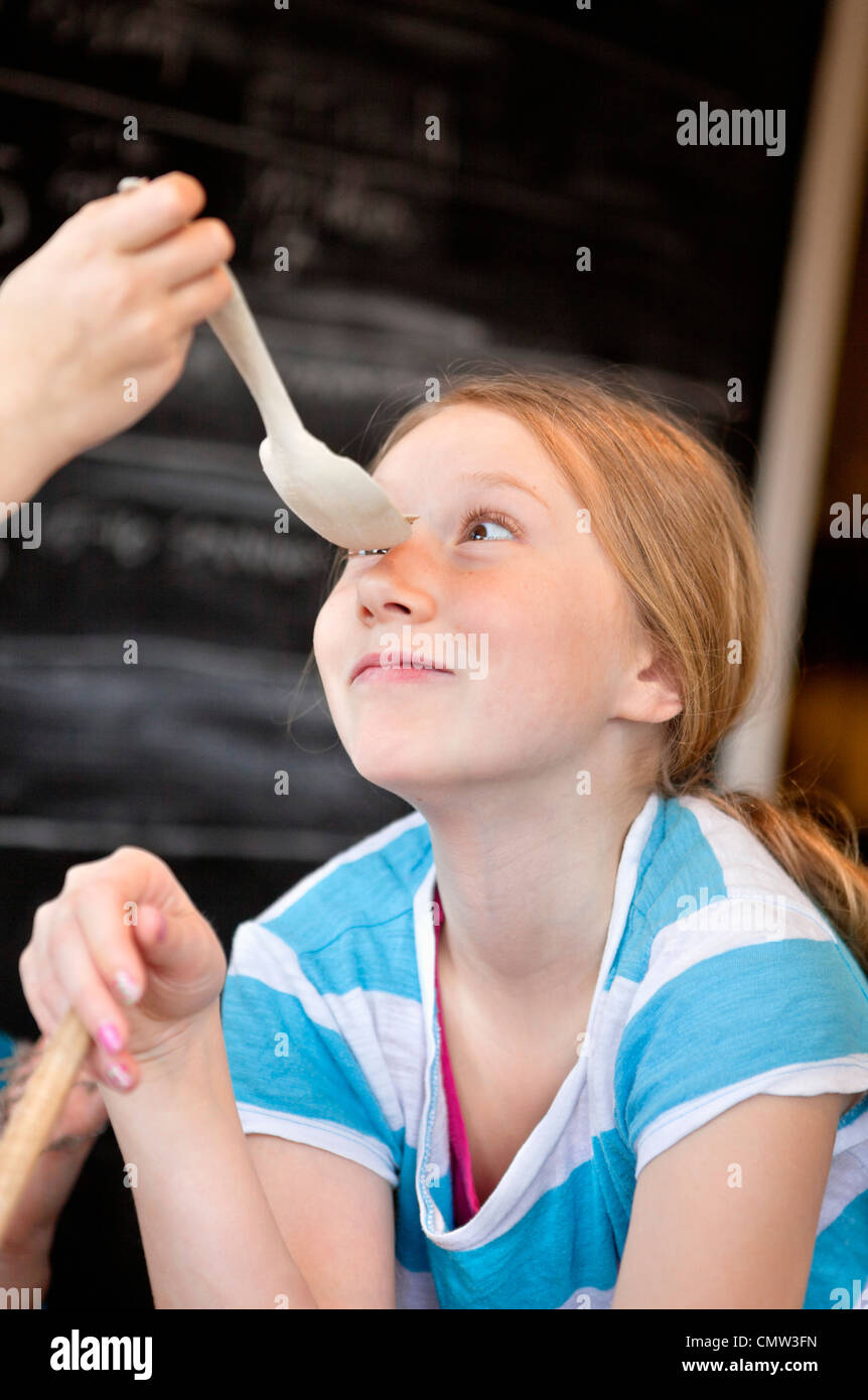 Girl playing with spoon Stock Photo - Alamy
