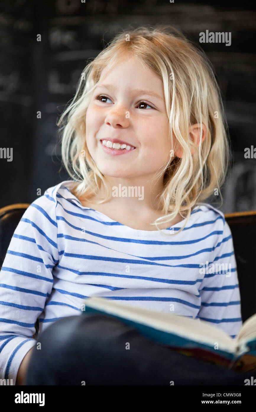 Happy girl studying while looking away Stock Photo - Alamy