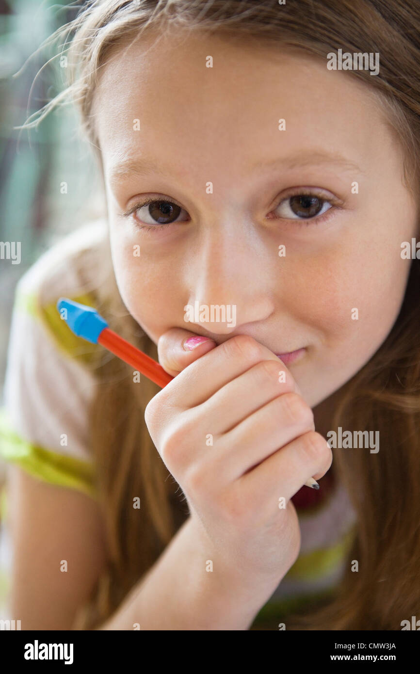 Portrait of girl holding pencil Stock Photo - Alamy