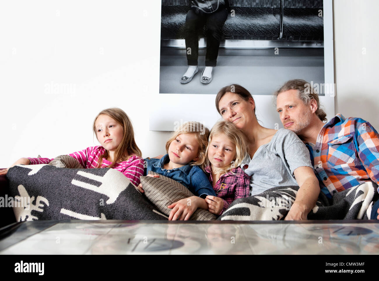 Bored family sitting on sofa looking away Stock Photo - Alamy
