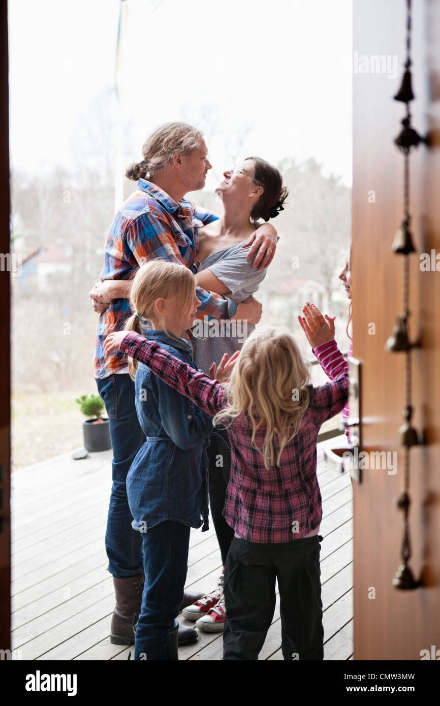 Parents embracing in front of their children Stock Photo - Alamy