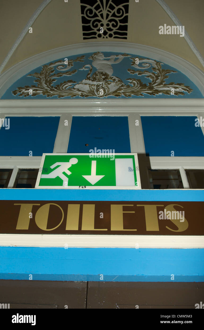 Art deco sign below modern illuminated fire escape sign Stock Photo - Alamy