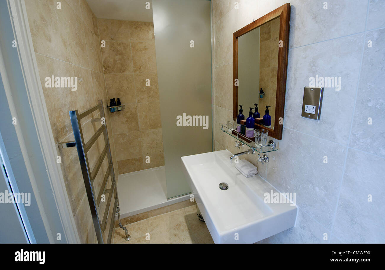 modern compact hotel show home bathroom wet room with oblong sink, wall ...