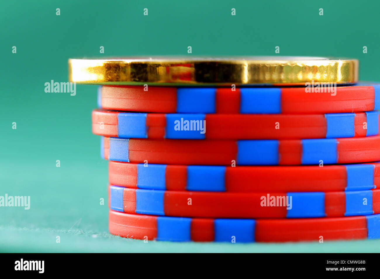 gambling chips and a gold chip on a green background Stock Photo - Alamy