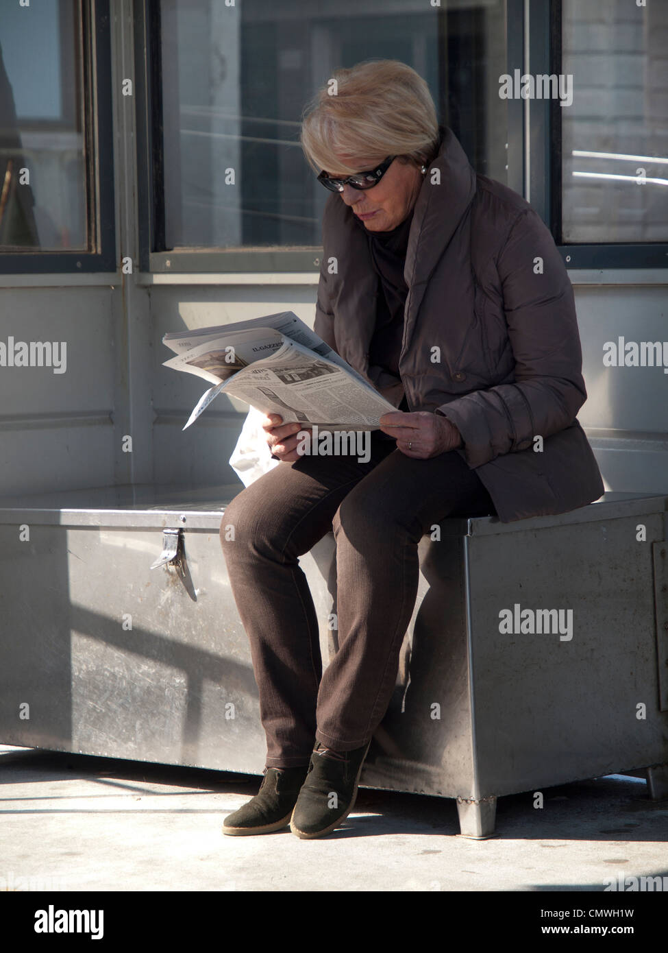 Reading newspaper bus stop hi-res stock photography and images - Alamy
