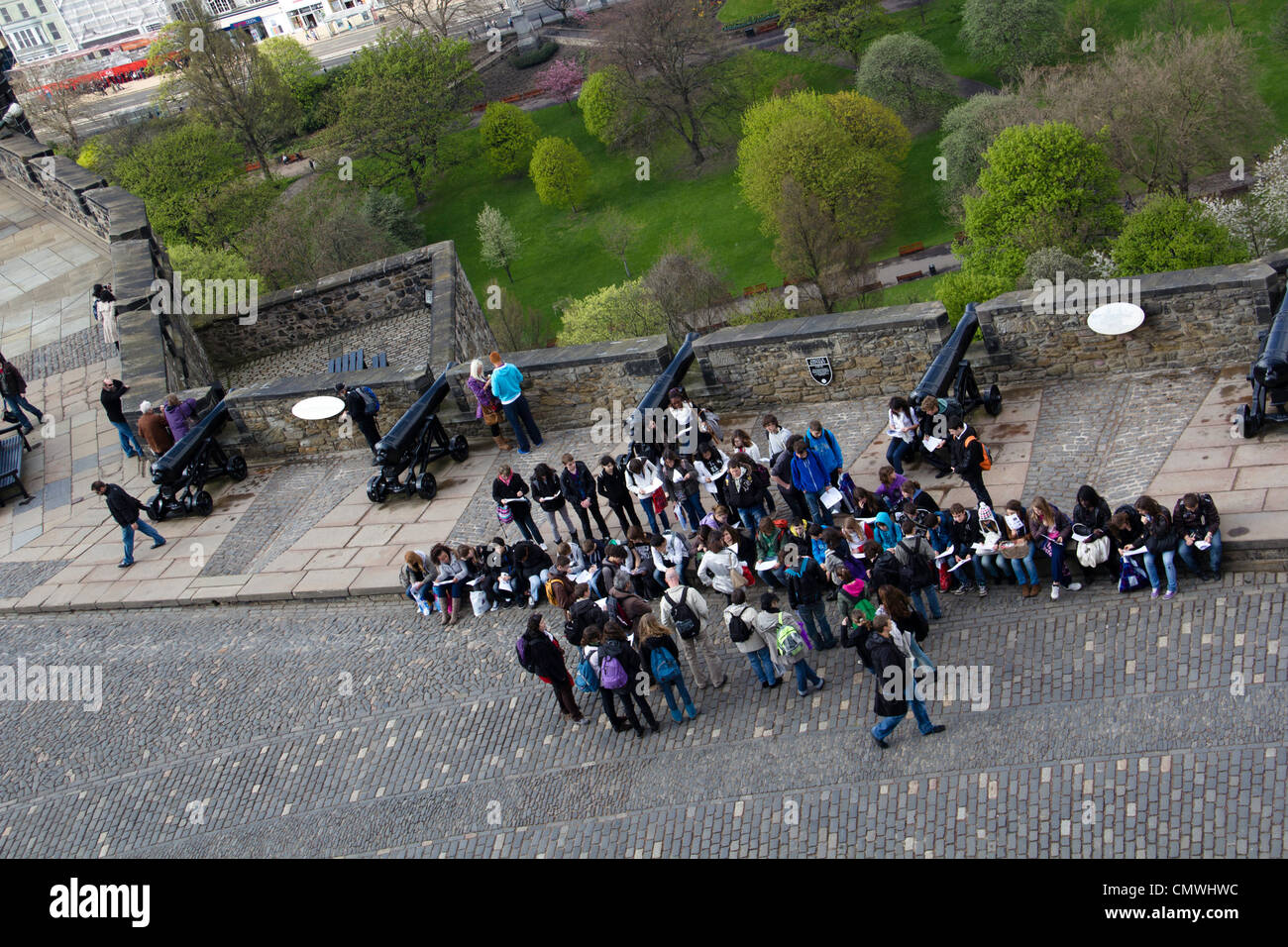 Young tourists at Edinburgh Castle, gathered around in a group near the ...