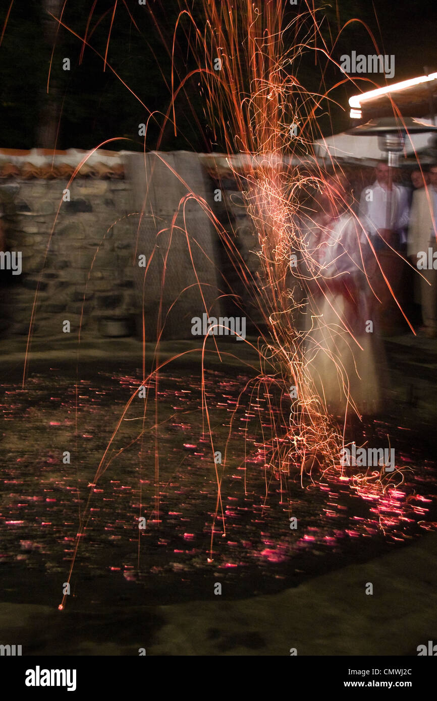 A woman dances with bare feet on the glowing hot embers, a ritual fire ...