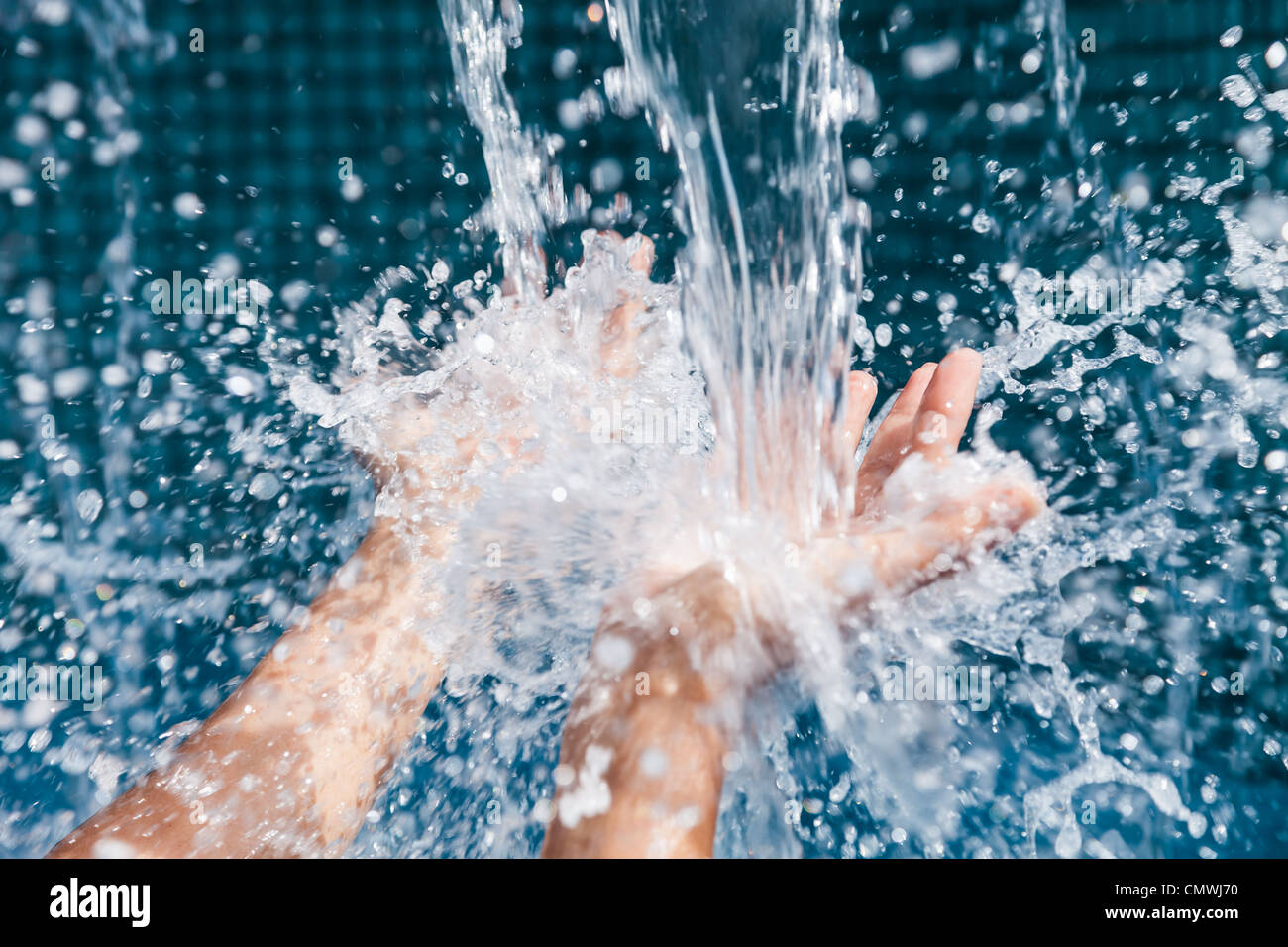 Water pouring with power into the hands of a woman Stock Photo - Alamy