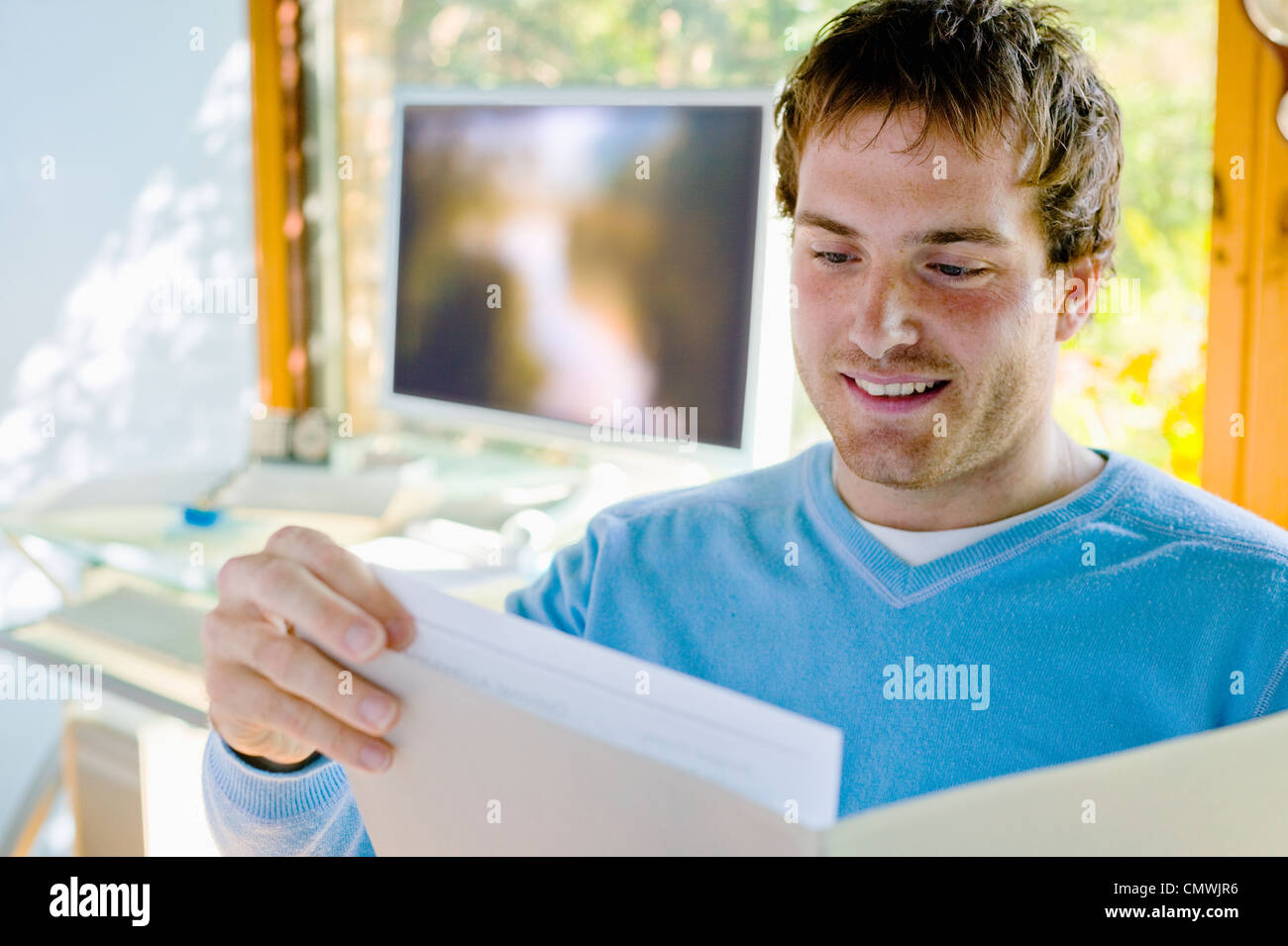 Man Reading a File in a Home Office Stock Photo - Alamy
