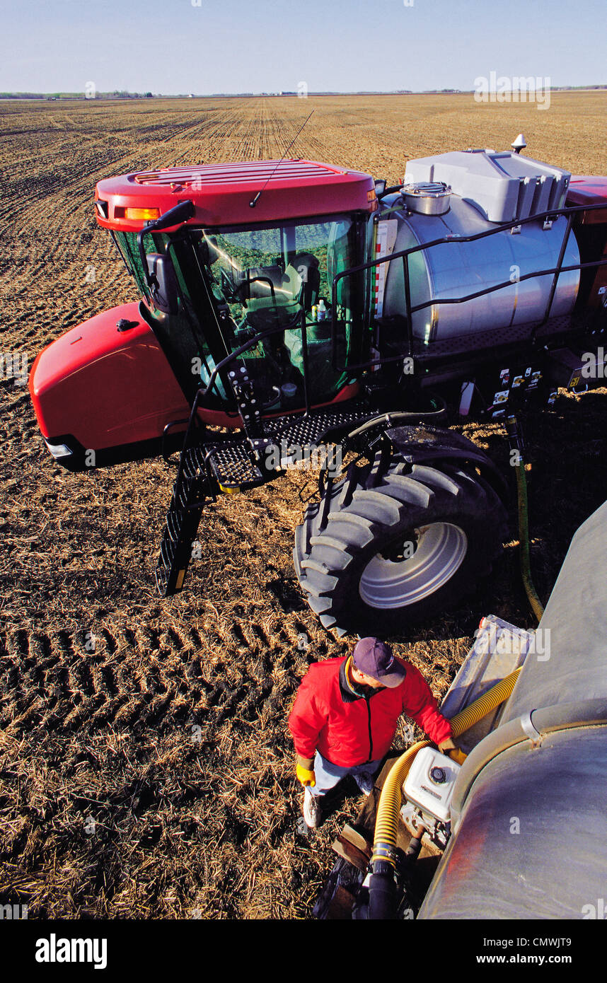 Farmer loads high Clearance Sprayer with liquid Fertilizer for ...
