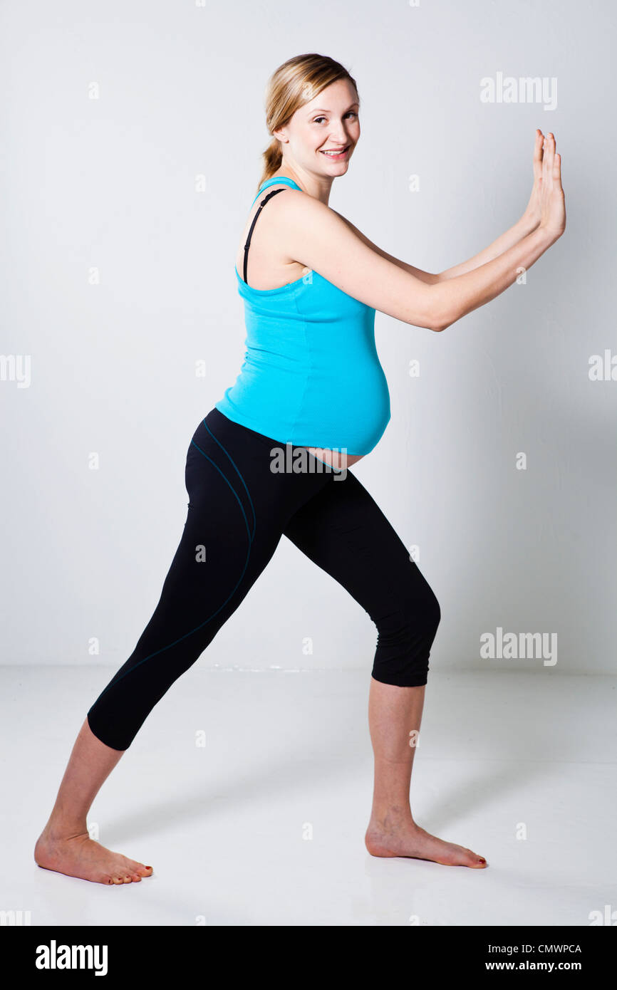 Pregnant woman performing a calf muscle stretching exercise Stock Photo ...