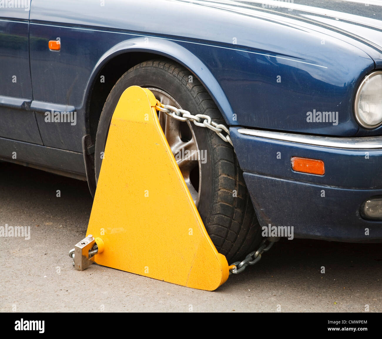 Wheel clamp attached to the wheel of a car Stock Photo - Alamy