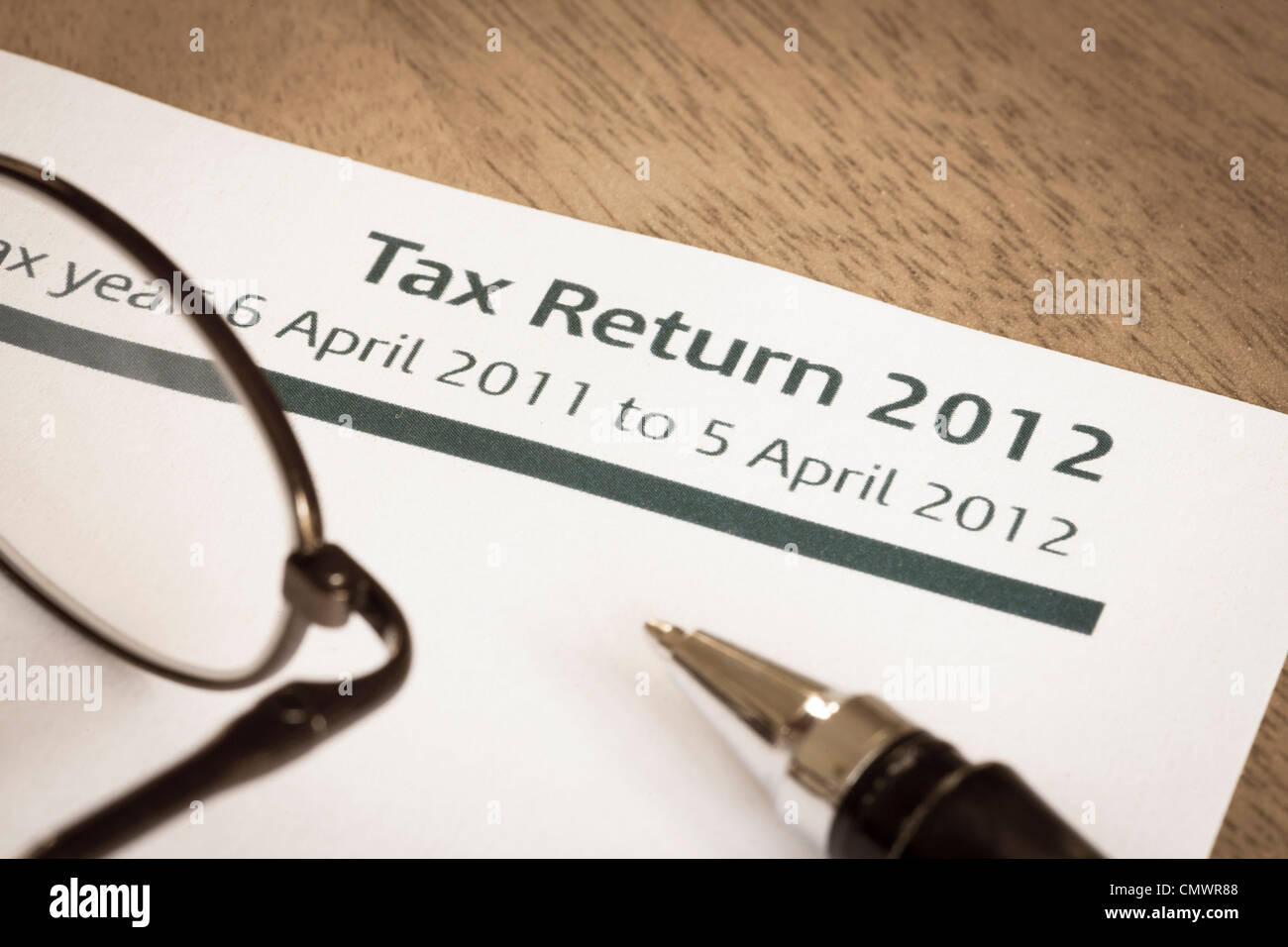 UK Income tax return form for 2012 on a desk with pen and spectacles ...