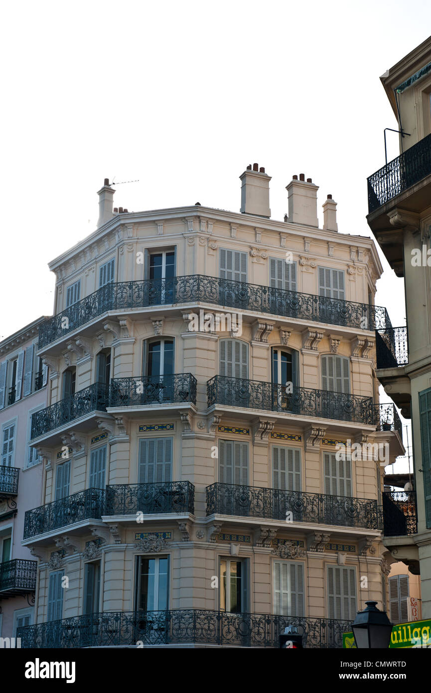 A low angle shot of black, fancy balconies on a white, stone building ...