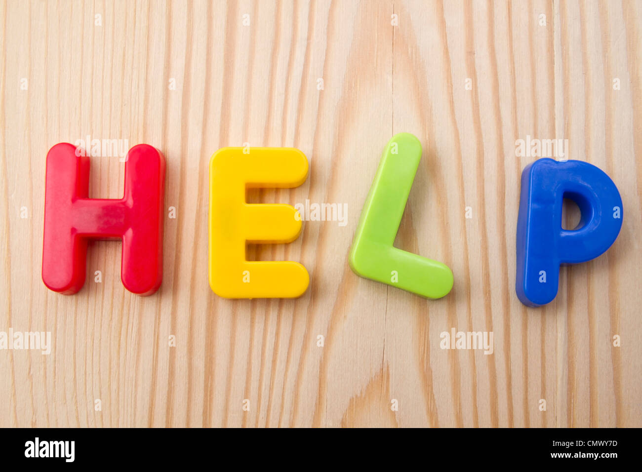 Letter magnet HELP closeup on wood background Stock Photo - Alamy