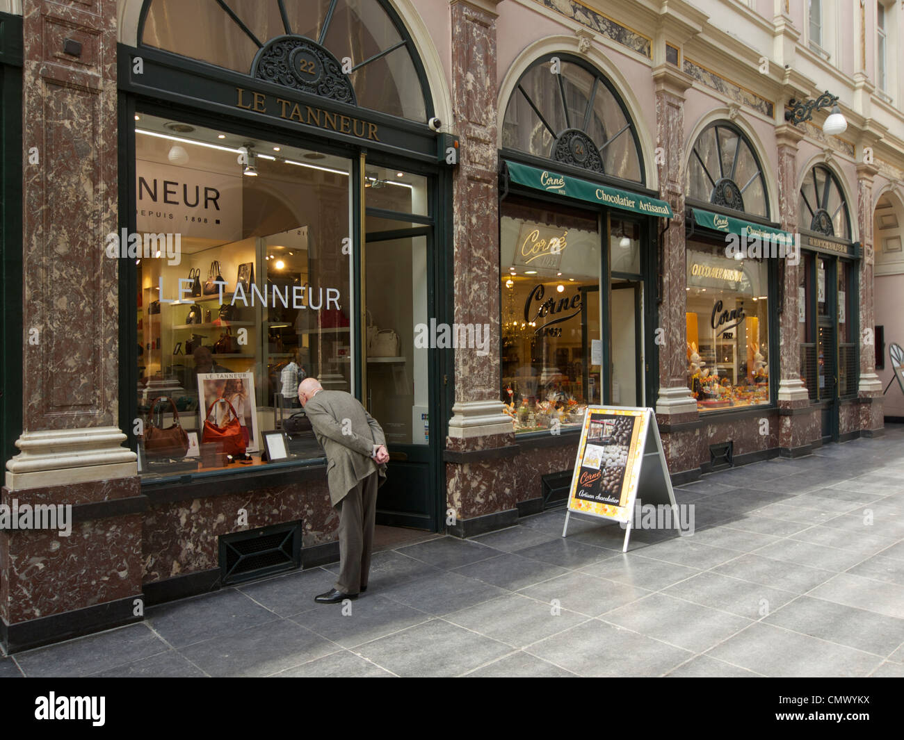 Older gentleman looking at shop window in the Galerie St. Hubert ...