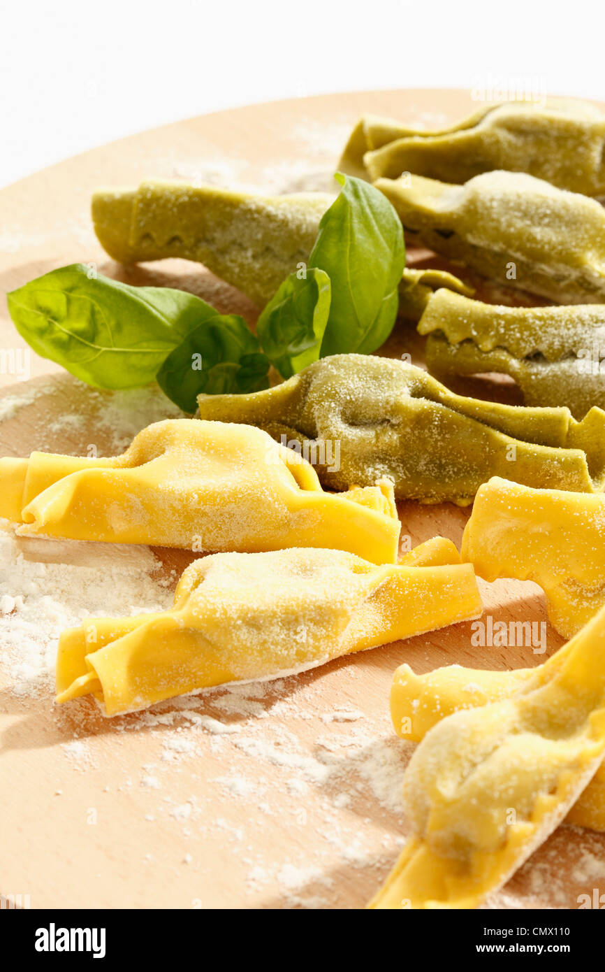 Candy shape pasta with flour and basil leaf on chopping board Stock ...