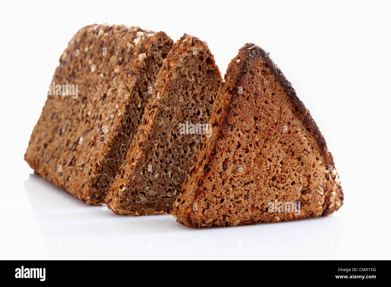 Multigrain rye bread loaf with slice on white background, close up ...