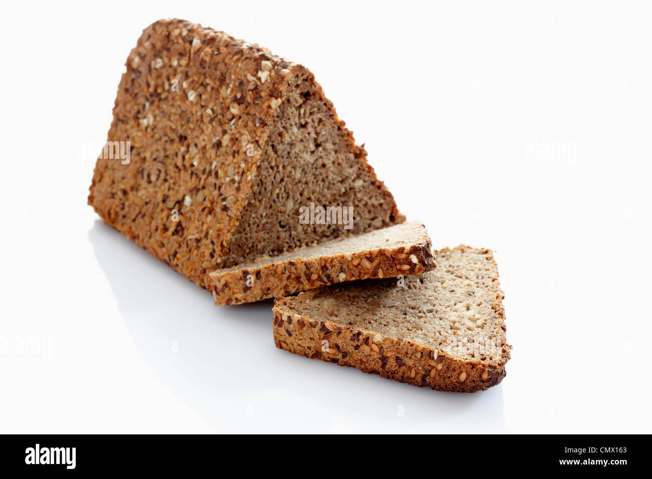 Multigrain rye bread loaf with slice on white background, close up ...