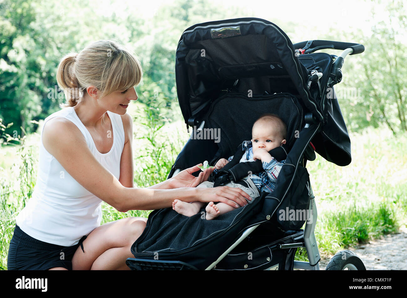 Germany, Munich, Mother crouching near baby boy, smiling Stock Photo ...