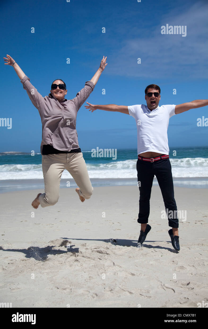 Couple jumping on beach Stock Photo - Alamy