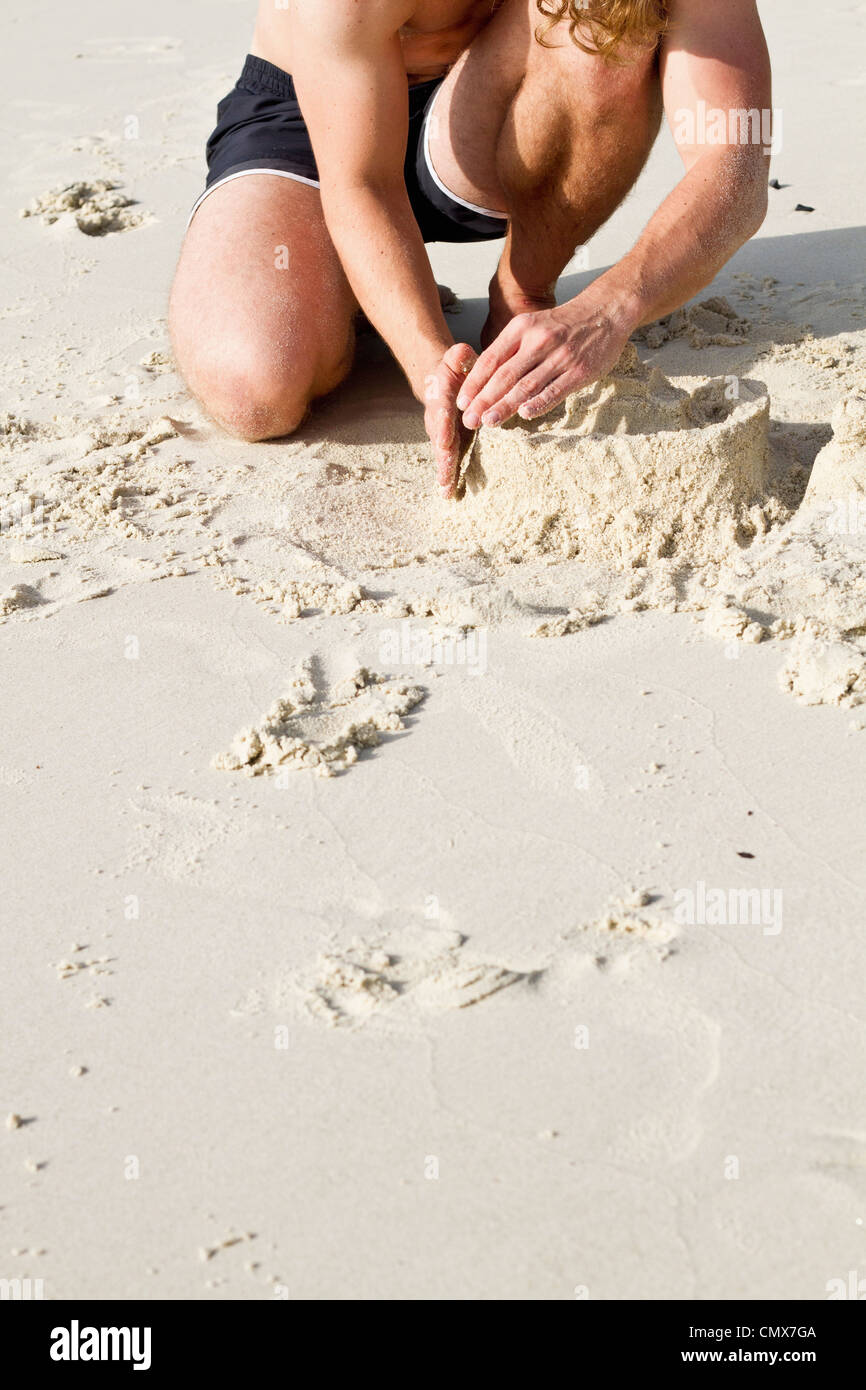 Man building sandcastle on the beach hi-res stock photography and ...