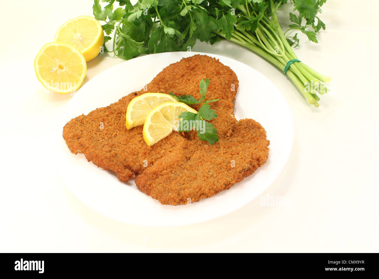 freshly roasted wiener schnitzel with lemon slices and parsley Stock Photo - Alamy