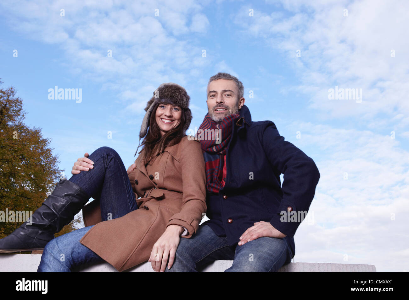 Germany, Cologne, Couple sitting on bridge, smiling, portrait Stock ...