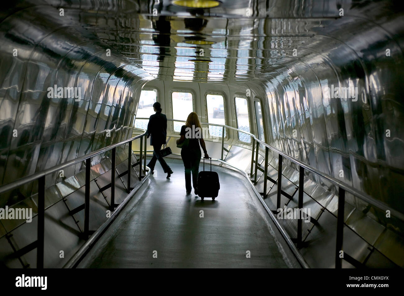 Passengers walking down to the plane through a air bridge walkway Stock ...