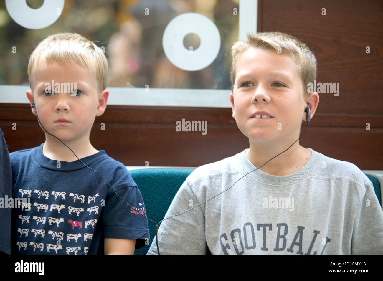 two children sharing headphones and listening to music Stock Photo - Alamy