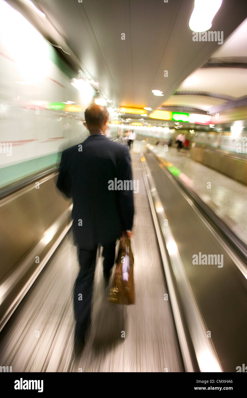 Passenger walking along moving walkway at Heathrow airport Stock Photo ...