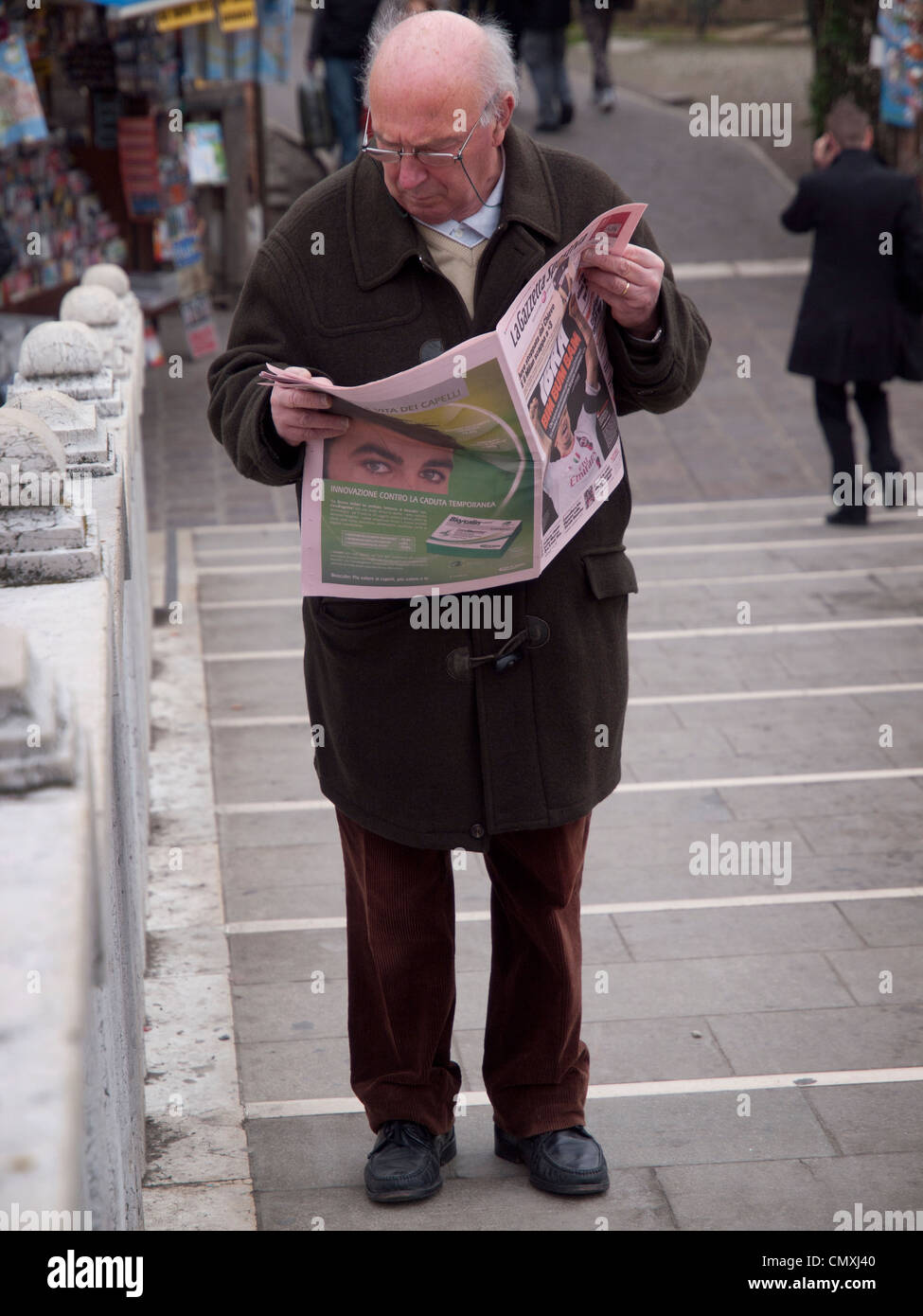 On a bridge in Venice a man stops to read a newspaper Stock Photo - Alamy