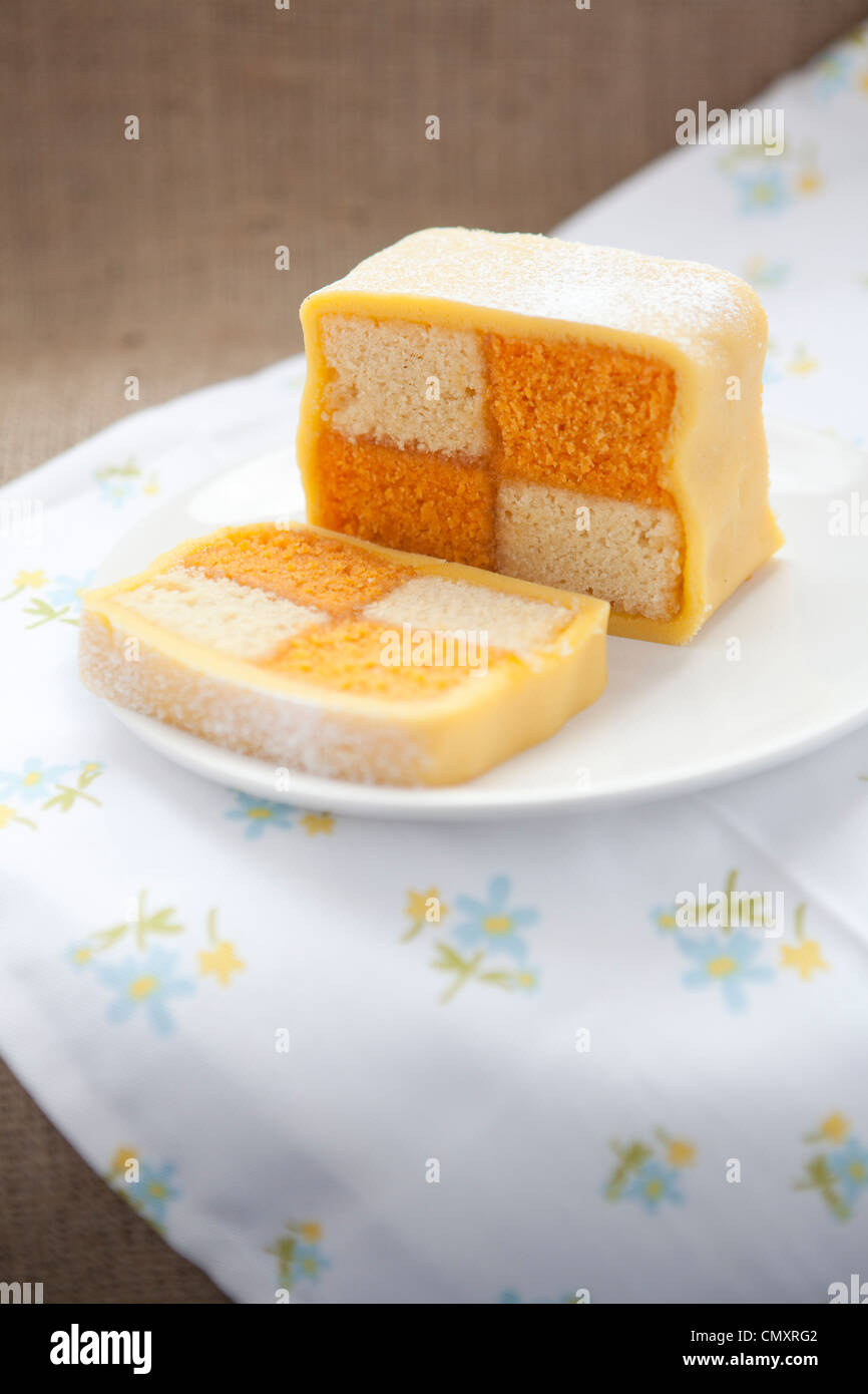 Homemade Battenburg cake on a floral sheet against hessian material ...