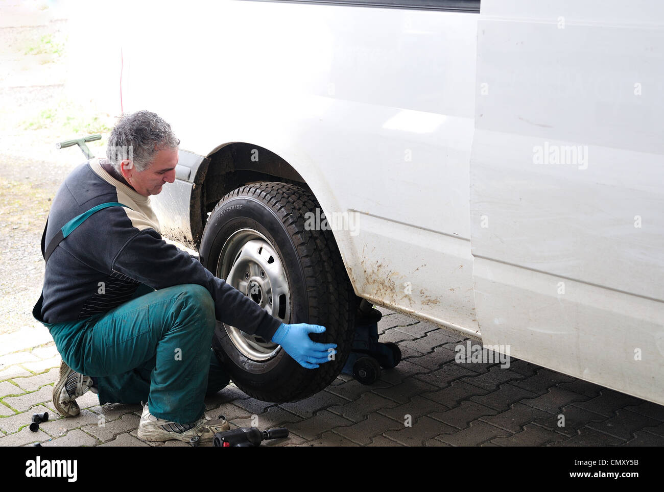 Man changing a wheel Stock Photo - Alamy