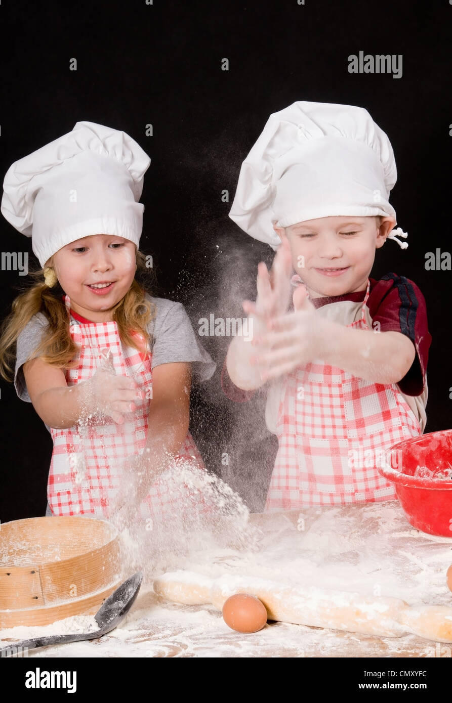 Two children plays with the flour on dark background Stock Photo - Alamy