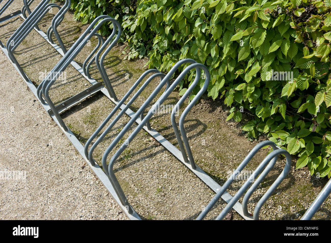 A reflective, color shot of an empty, gray bike rack positioned in ...