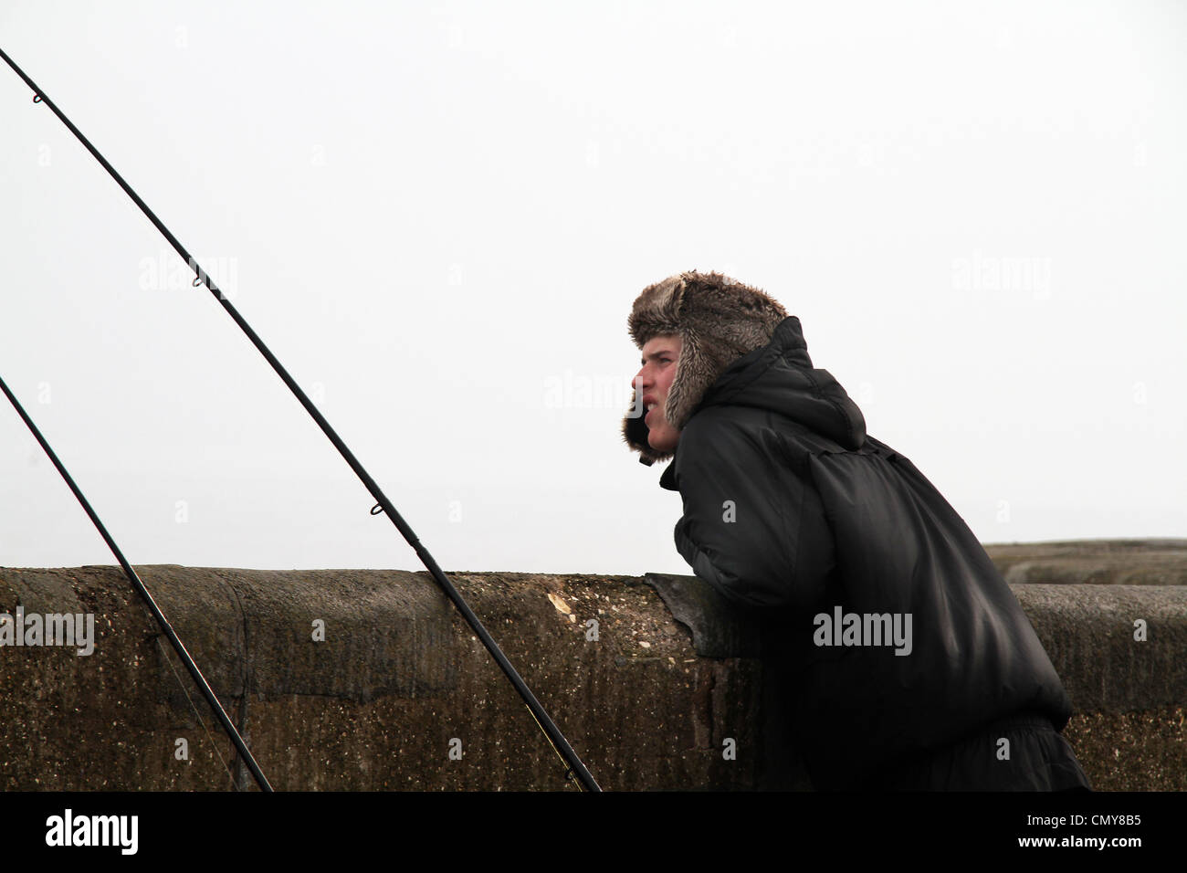 Sea fishing from a harbor wall Stock Photo - Alamy