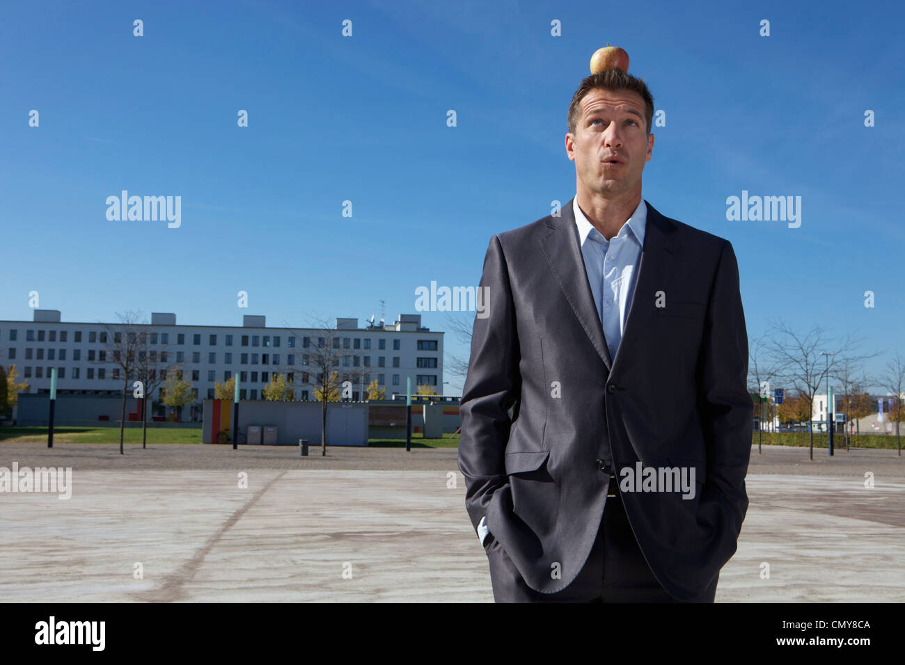 Germany, Bavaria, Munich, Businessman with apple on his head Stock ...