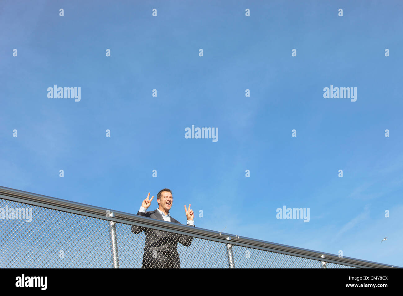 Germany, Bavaria, Munich, Businessman standing near railings, smiling ...