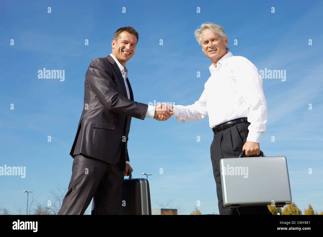 Germany, Bavaria, Munich, Business people shaking hands, smiling ...