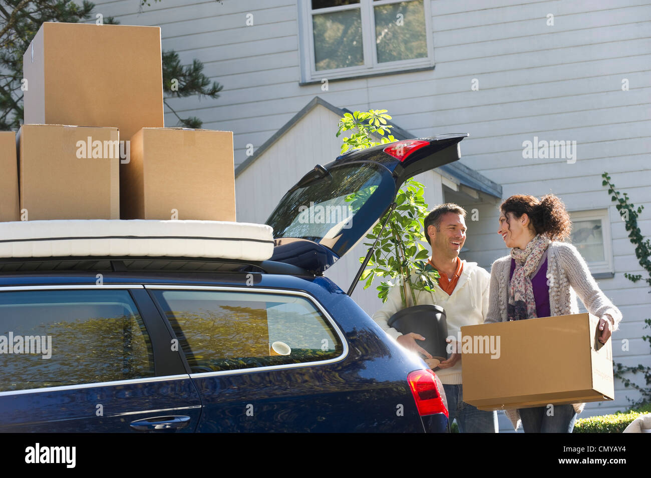 Germany, Bavaria, Grobenzell, Couple loading boxes into car, smiling ...