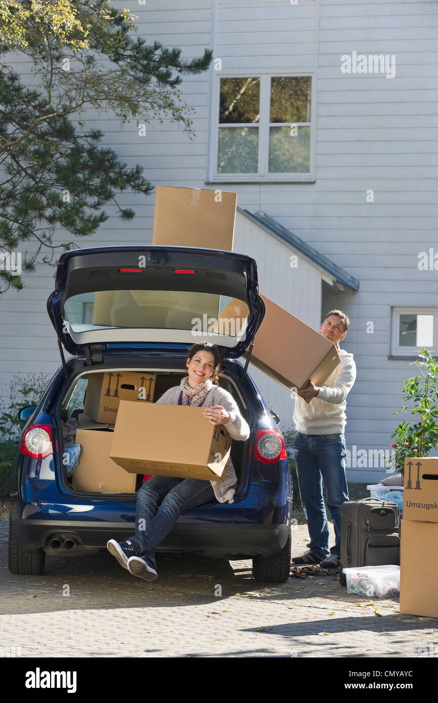 Germany, Bavaria, Grobenzell, Couple loading boxes into car, smiling ...