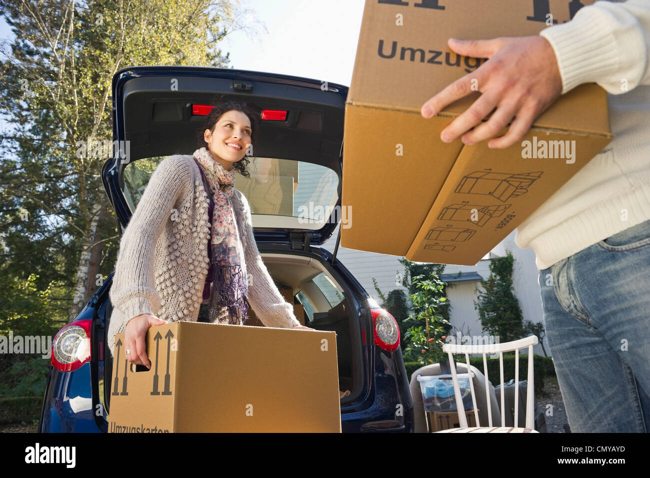 Germany, Bavaria, Grobenzell, Couple loading boxes into car, smiling ...