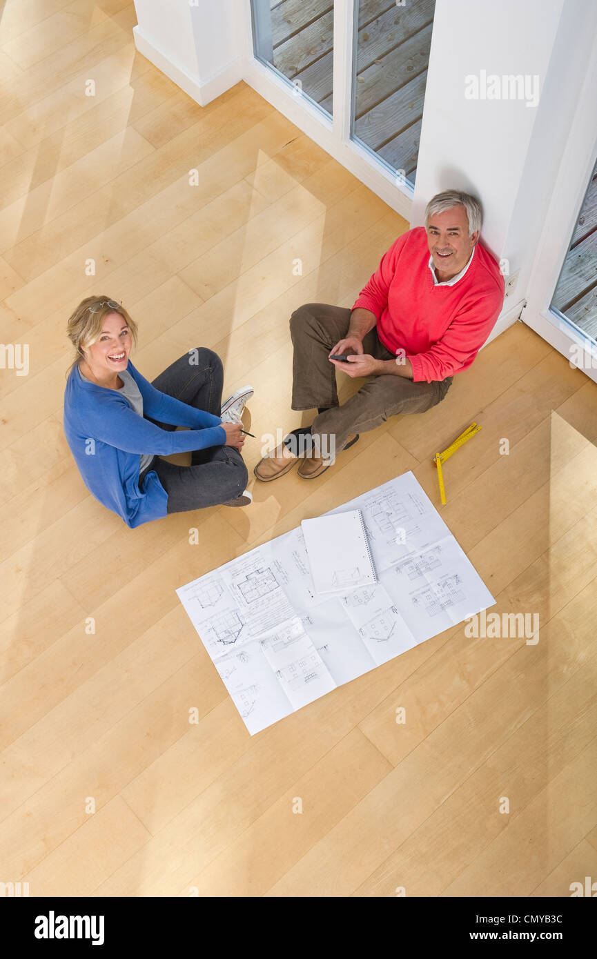 Germany, Bavaria, Grobenzell, Couple with blueprint in house, smiling ...