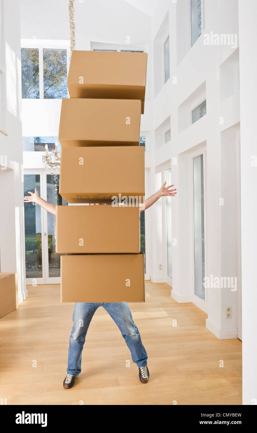Germany, Bavaria, Grobenzell, Mature man carrying stack of falling ...