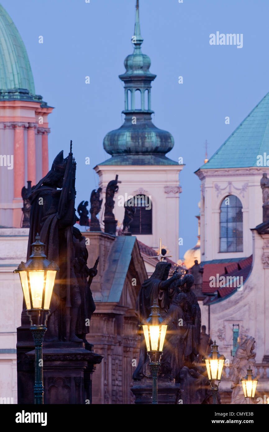 prague - religious art on charles bridge, lanterns and spires of the ...