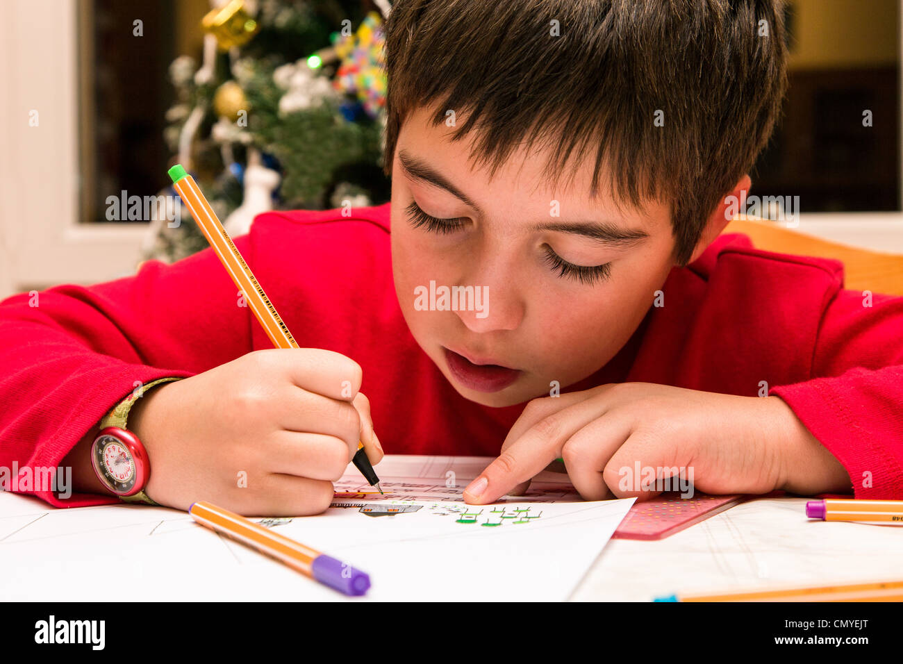 Little boy concentrated on making a drawing during Christmas time Stock ...