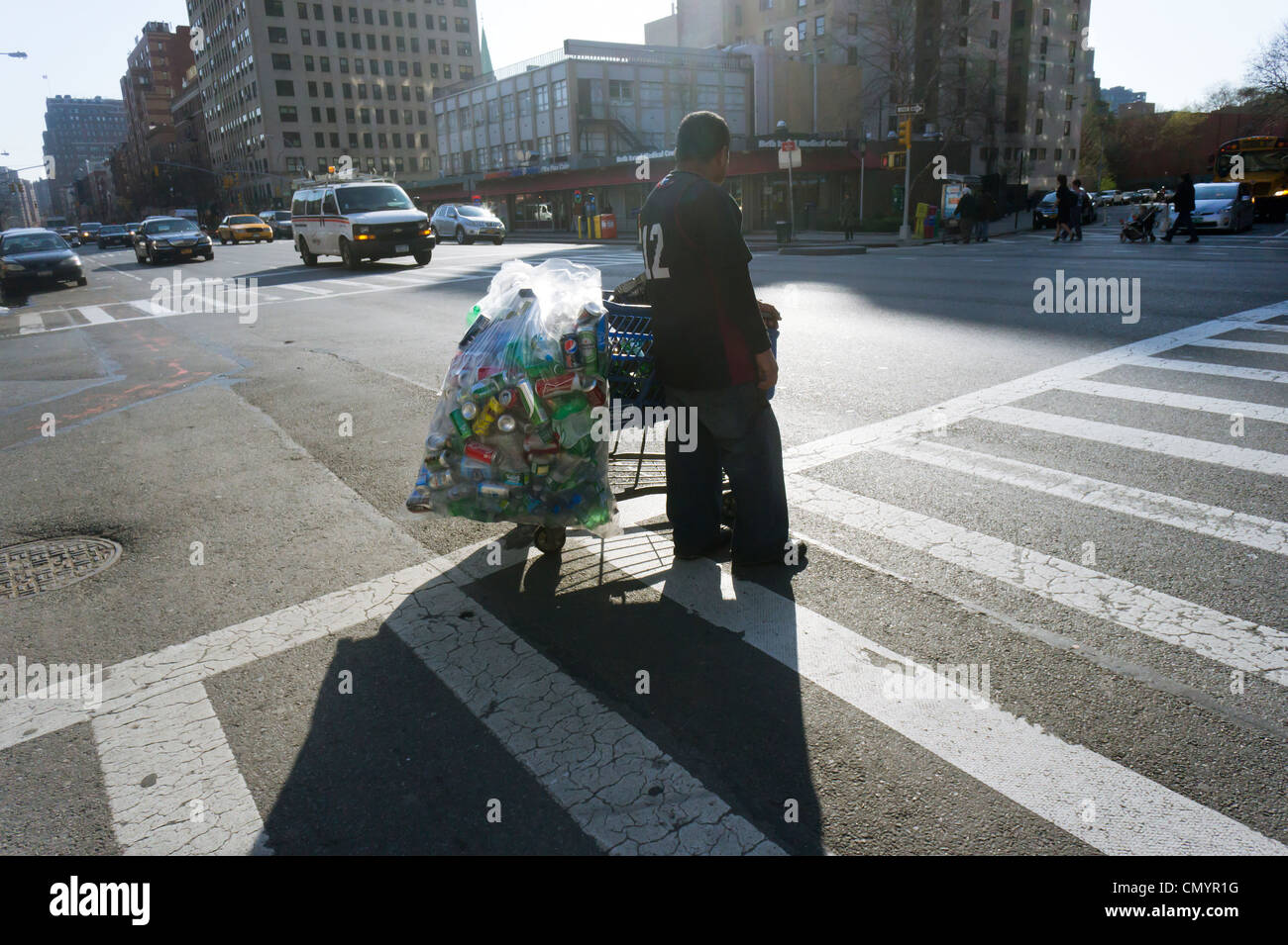 A bottle collector with a shopping cart full of recyclables on his way ...