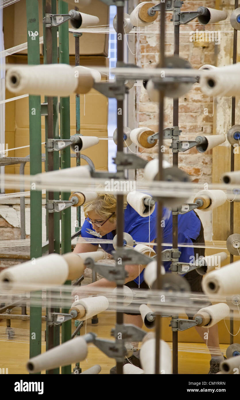A worker runs a warping creel at the Amana Woolen Mill Stock Photo - Alamy