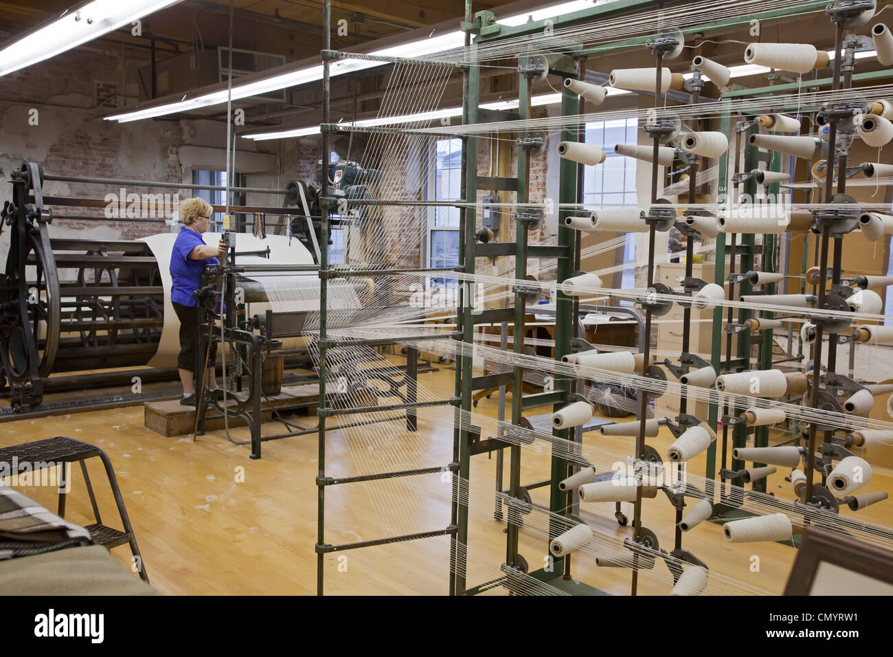 A worker runs a warping creel at the Amana Woolen Mill Stock Photo - Alamy